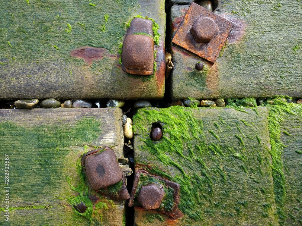 Close up of sea wall on coastal barrier in wood bolted together with ...