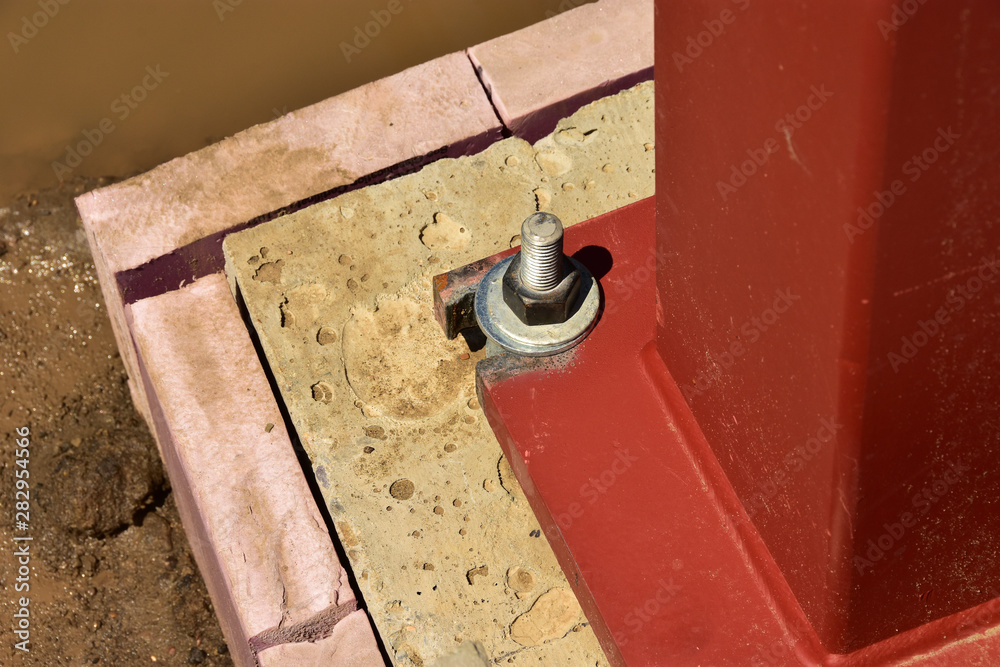 Steel beam bolted to concrete footing, base for new steel frame ...