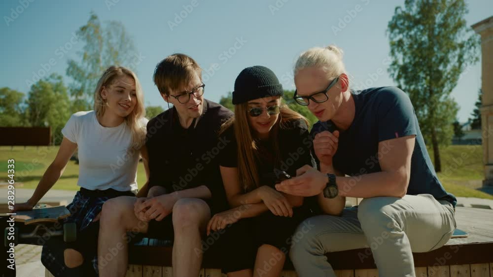 Stylish Cool Teenagers Chilling on the Benches in the Park, Using ...