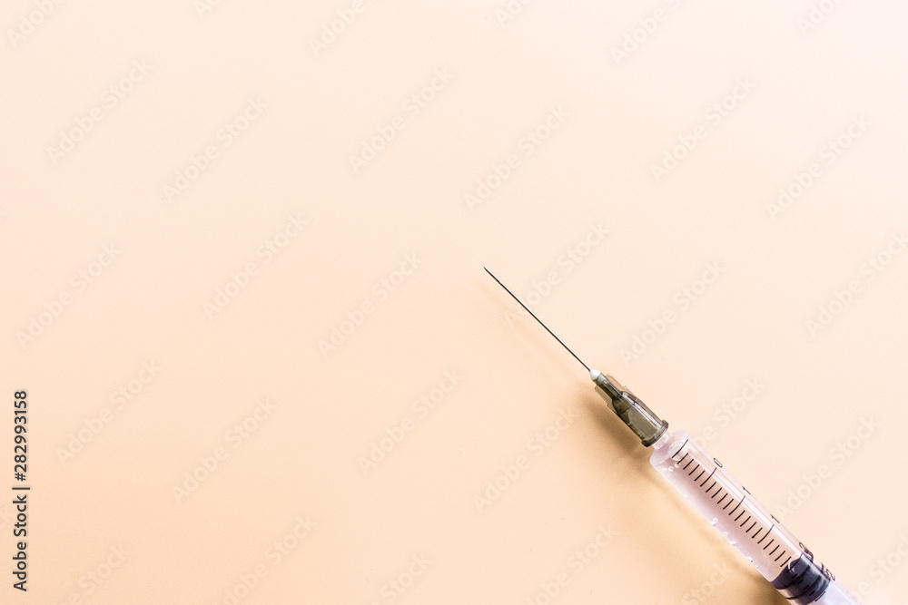 Medical syringe on pastel orange background, health and vaccination ...