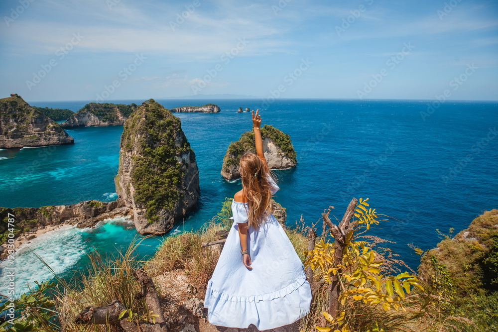 Young woman raised her hand up in Thousand island. Aerial view of Nusa Batumategan and Nusa ...