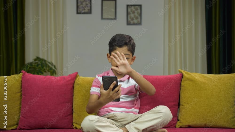 Vidéo Stock Young innocent kid busy doing a video call on his ...