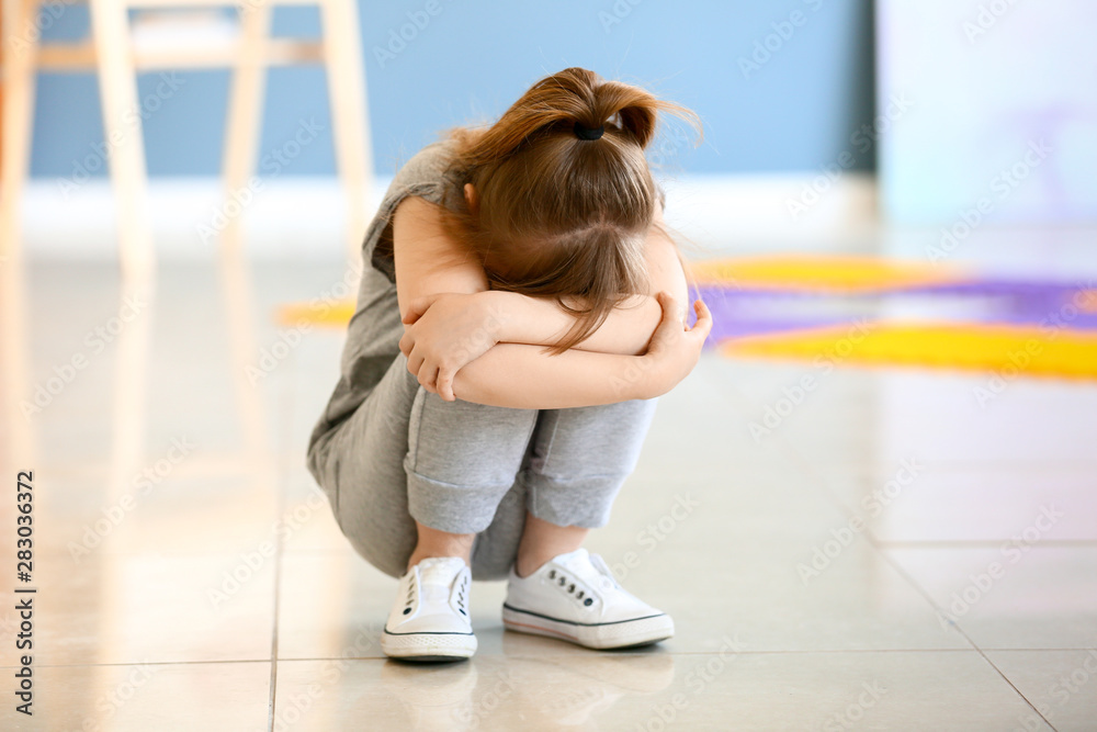 Sad little girl with autistic disorder in playroom Stock Photo | Adobe ...