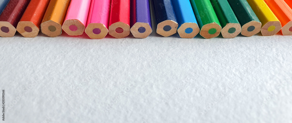 Wooden colored pencils, rainbow style, on the white sheet of drawing ...