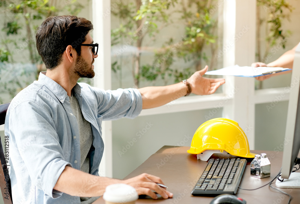 Engineer man receive the document from co-worker and sit in front of ...