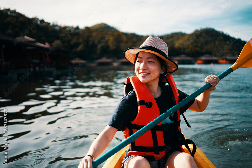 Asian girl is kayaking at Kanchanaburi, Thailand. Stock Photo | Adobe Stock