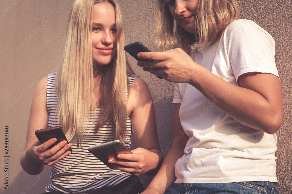 Group of multicultural friends using a smartphone outdoors. Hands of ...