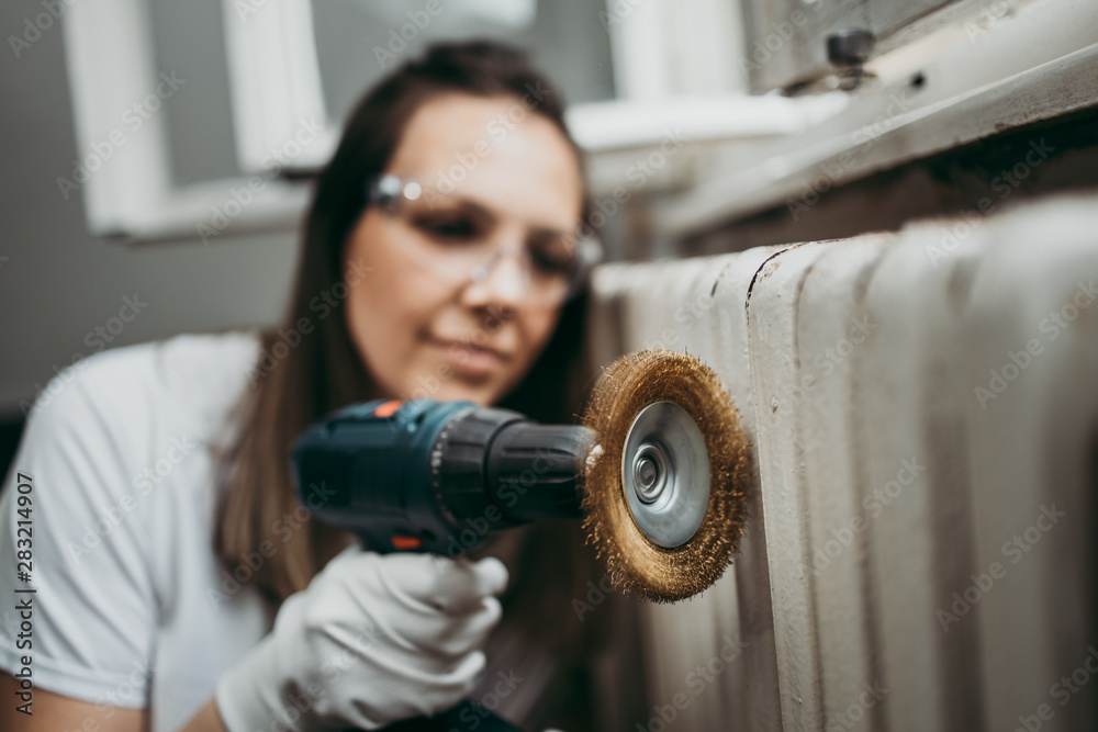 Beautiful and diligent middle age handy woman renovating her old home ...