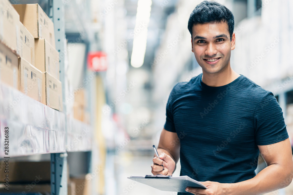 Smart Indian engineer man wearing safety helmet doing stock tick check ...