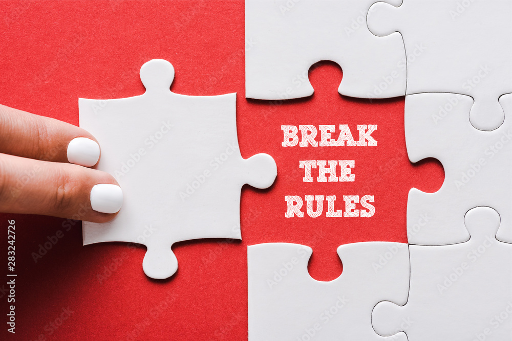 top view of woman touching jigsaw near break the rules lettering and ...