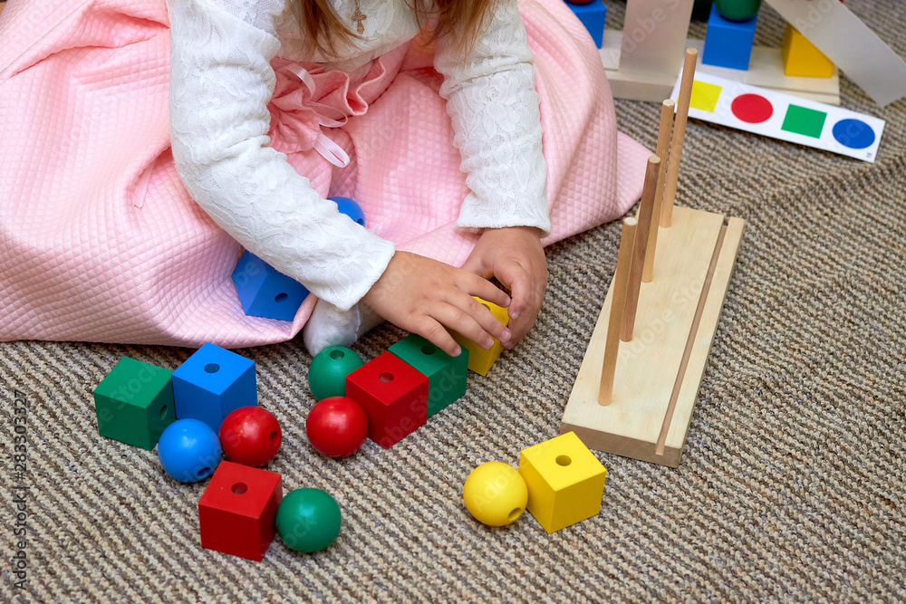 Little girl playing on the floor educational game with geometric shapes ...