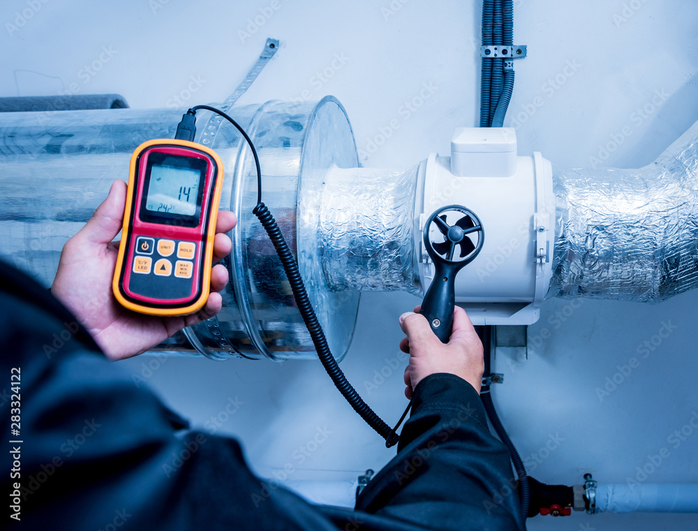 Photo & Art Print Technician use hand-held anemometer measuring air ...
