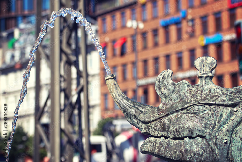 Copenhagen, Denmark - Dragon head spouting water with blurred city ...