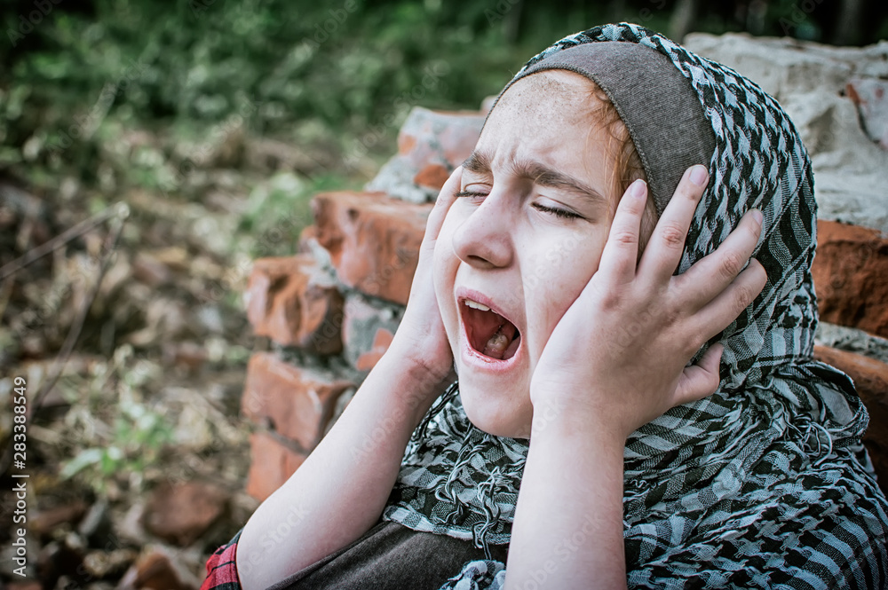 a refugee child in the war, a Muslim girl with a dirty face on the ...