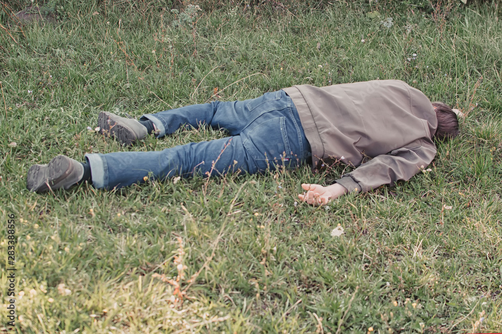 Foto de The corpse of a tramp in the grass. Criminal. Alcoholic ...