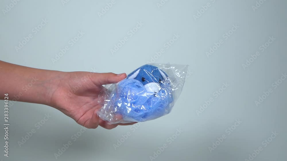 Close up view of kids hands holding new cute blue shower puff with ...