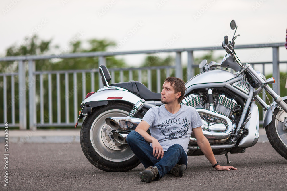 Handsome rider man sitting next to modern powerful shiny motorcycle on ...