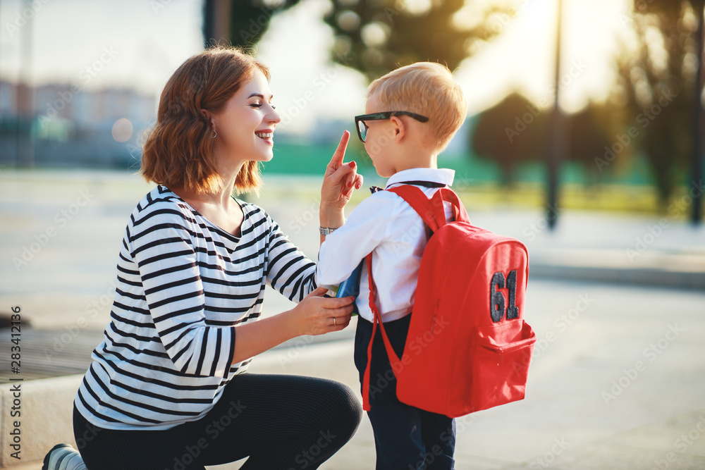first day at school. mother leads little child school boy in first ...