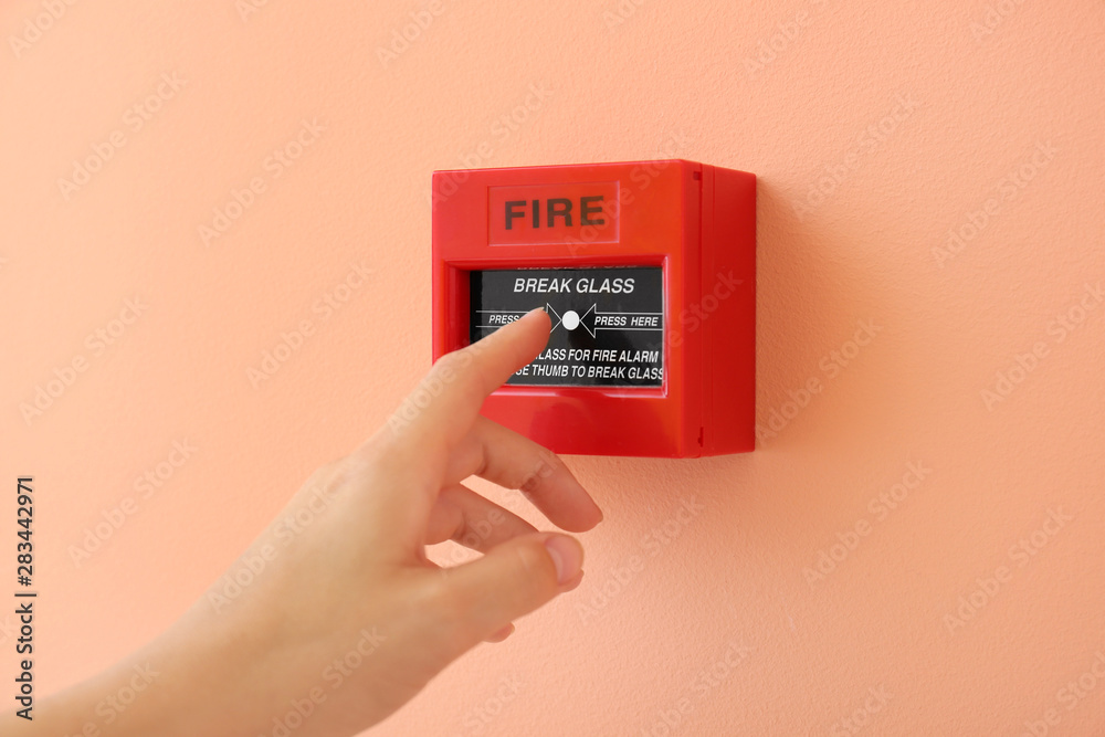Woman using manual call point of fire alarm system Stock Photo | Adobe ...