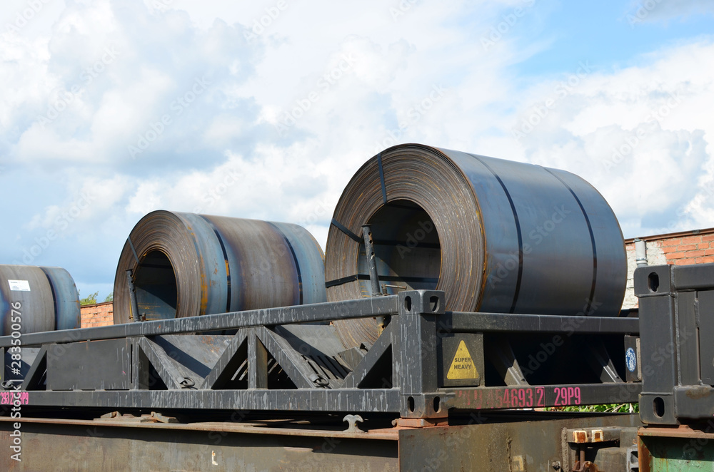 Rolled steel coil on on a freight train fixed by a chain. Import/export ...