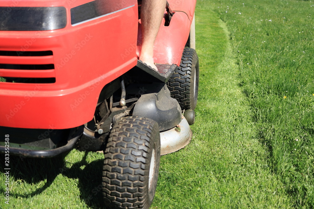 Red riding lawn mower (lawnmower, ride-on mower) in garden. Stock Photo ...