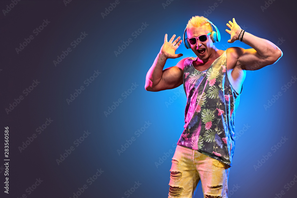 Fashion Excited Muscular DJ man dance music, colorful neon light ...