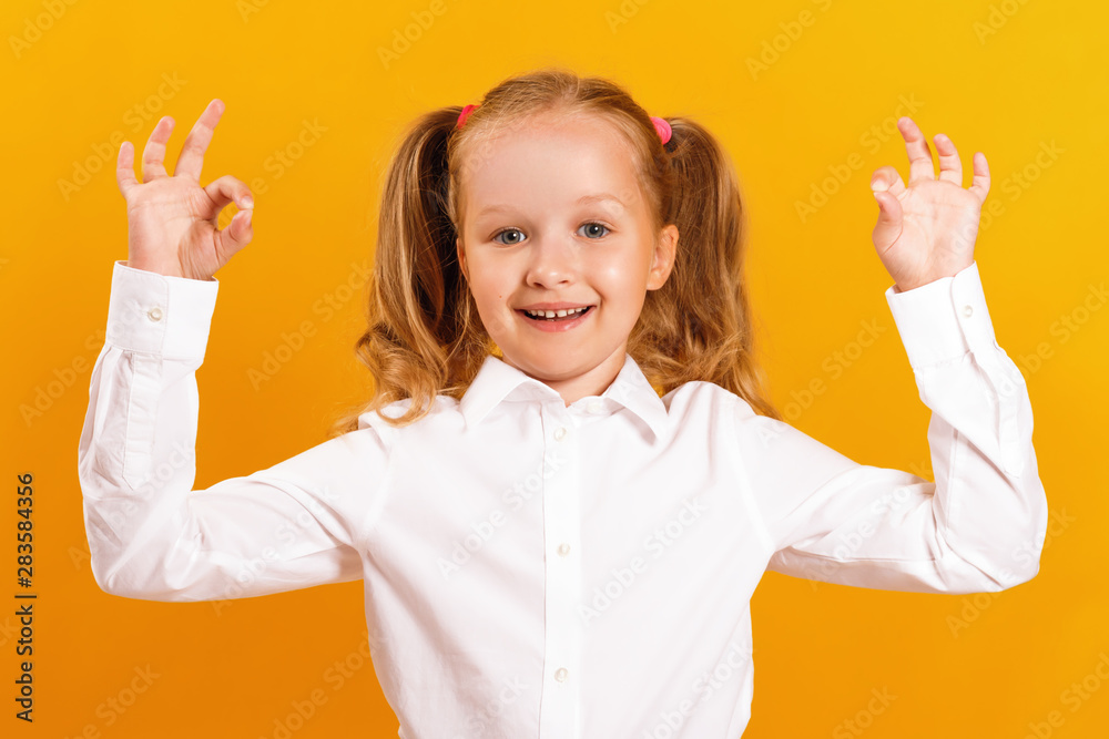 Cute smiling little girl shows ok sign with two hands. The concept of ...