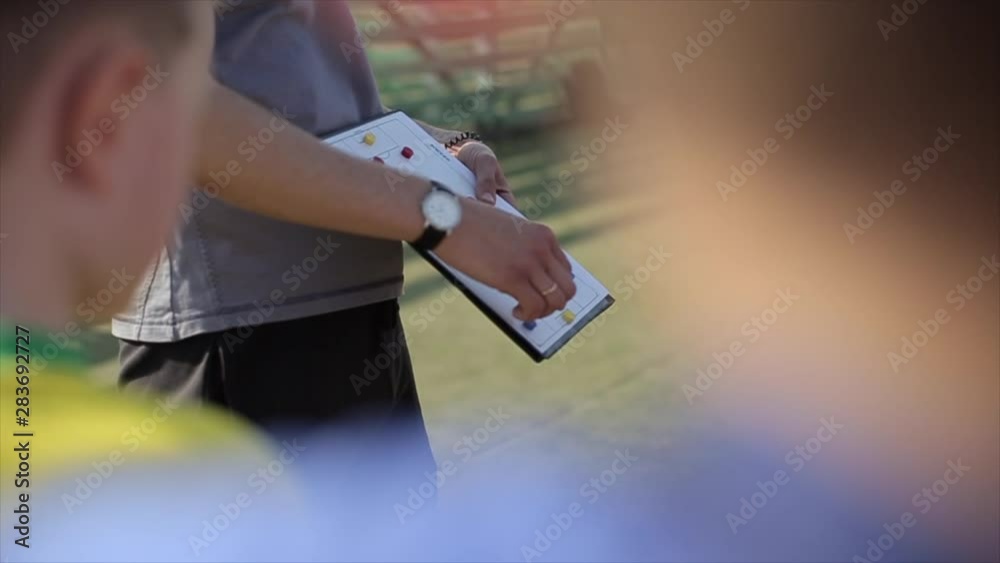 Young Football coach trainer coaching kids using tactic strategy ...