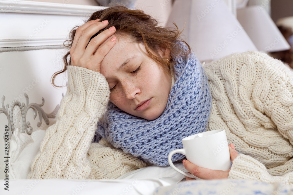 Sad alone young woman in white sweater and blue scarf feeling headache ...