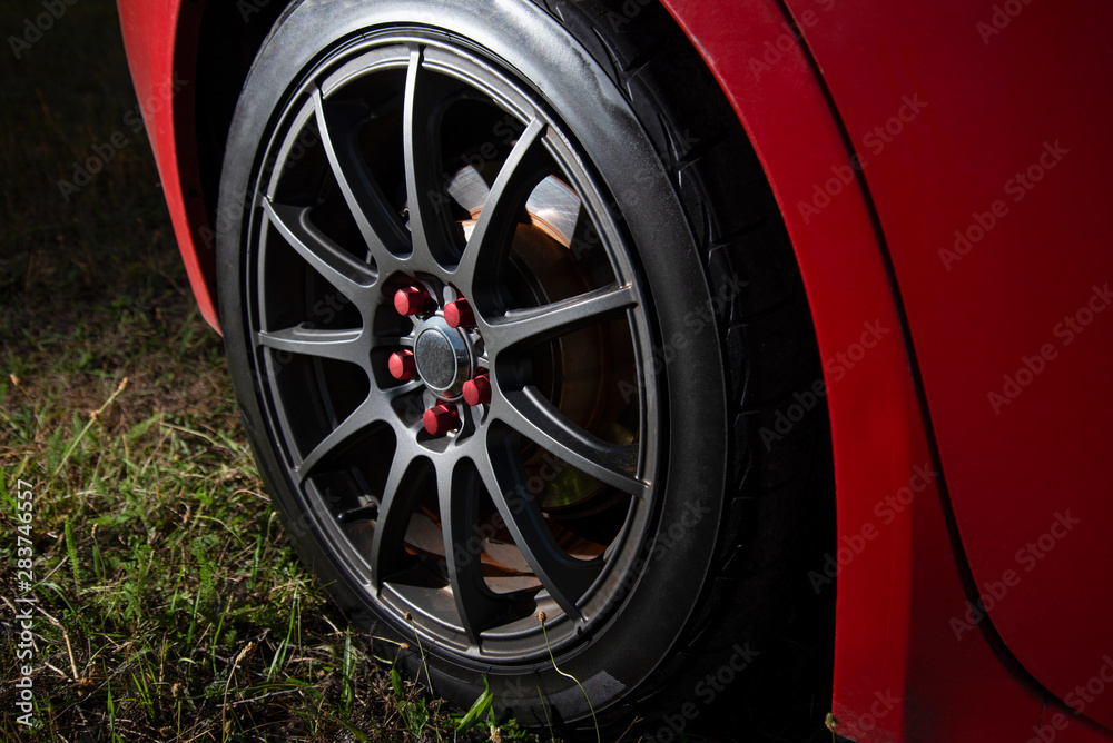 car wheel with alloy wheel gray color on red car Stock Photo | Adobe Stock
