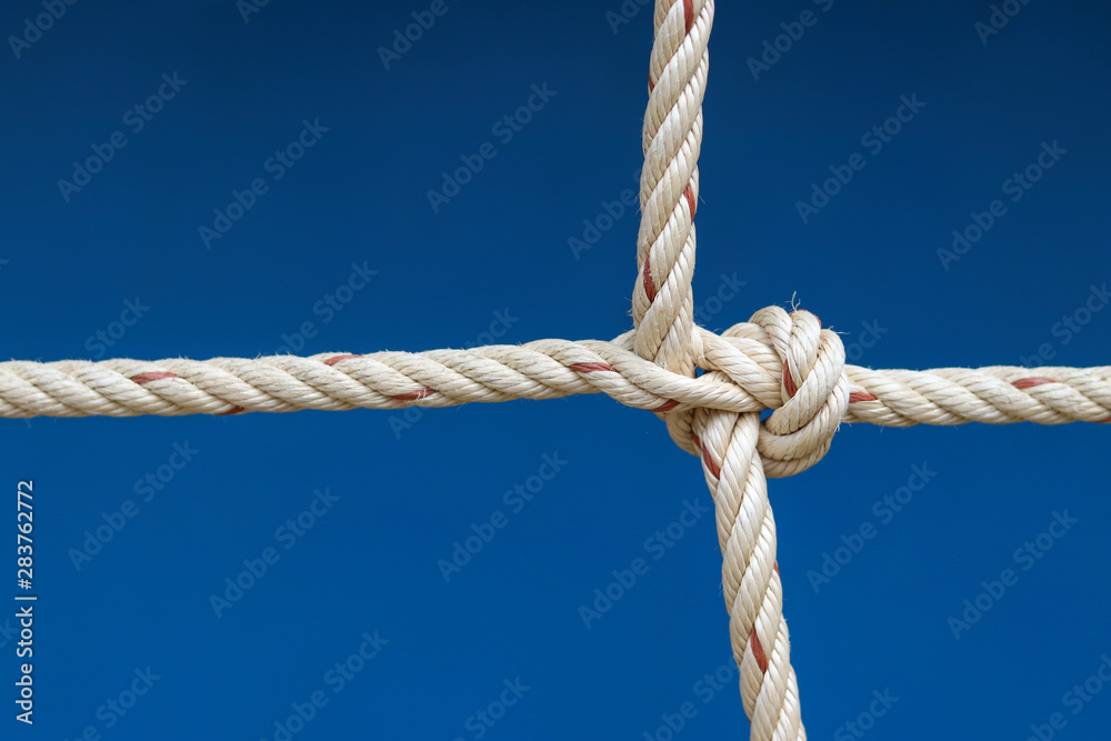 Nylon rope tied into a knot with blue background. Stock Photo | Adobe Stock