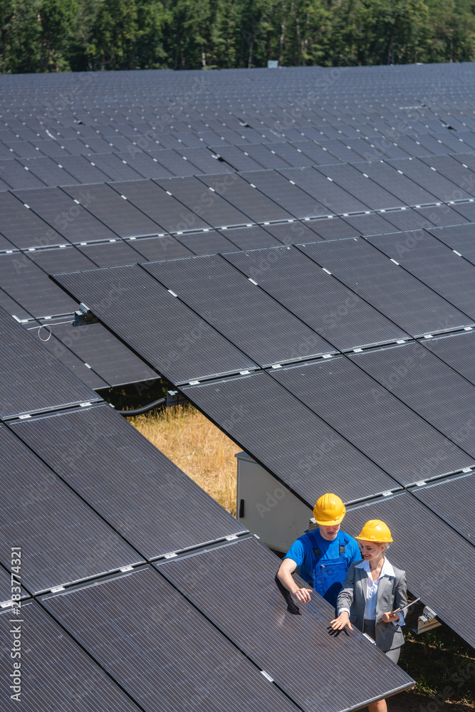 Two people standing amid solar cells in a power plant Stock Photo ...
