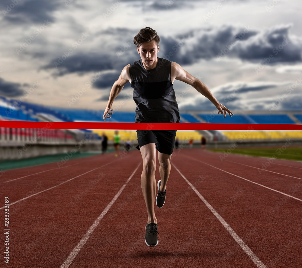 Sporty man running on the athletic track Stock Photo | Adobe Stock