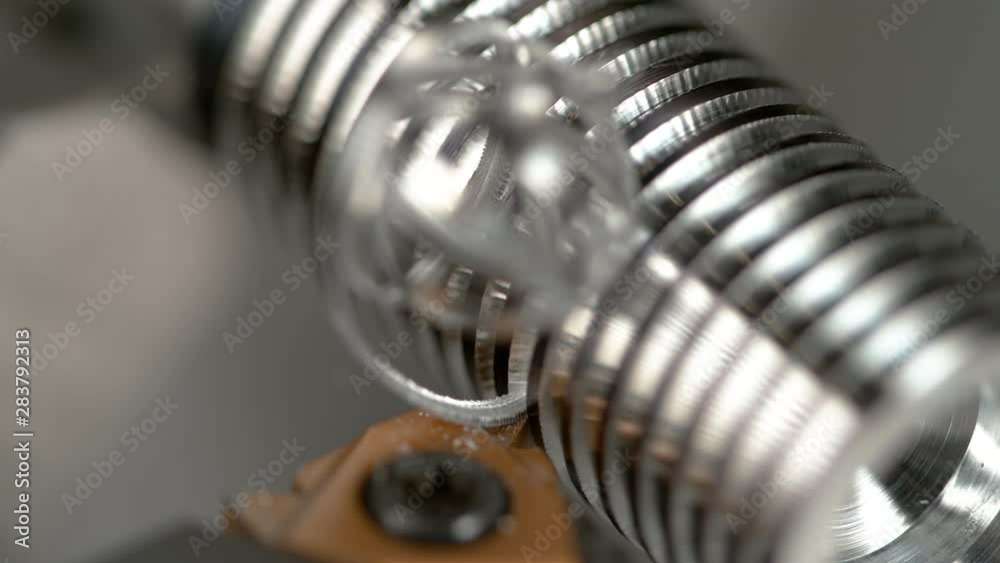 SLOW MOTION, MACRO, DOF: Curly shavings break off a small metal rod ...