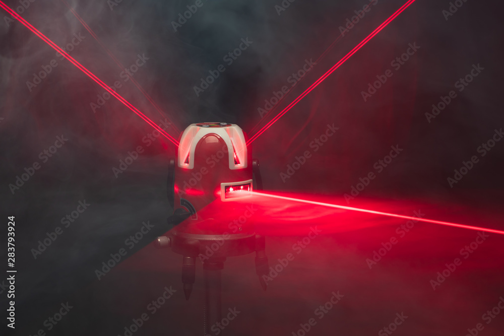 laser level tool red light beams in smoke Stock Photo | Adobe Stock