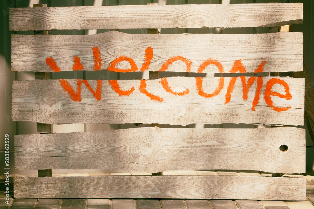 Welcome. Inscription on gray wooden board. Plank surface texture, board ...