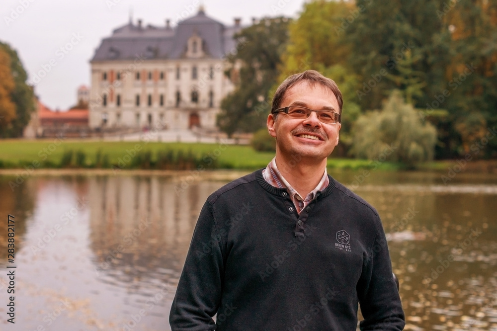 Smiling middle-aged man in the Park in the autumn on the background of ...