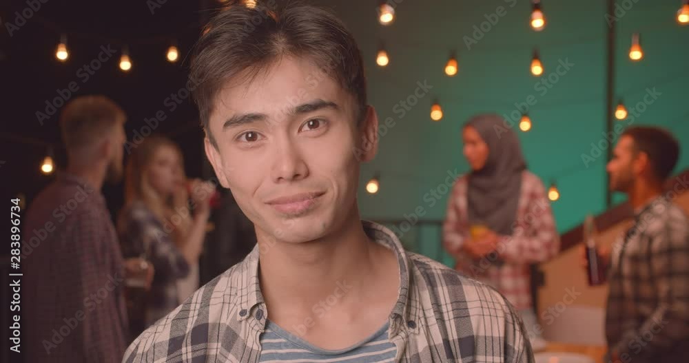 Closeup portrait of young asian man looking at camera smiling happily ...