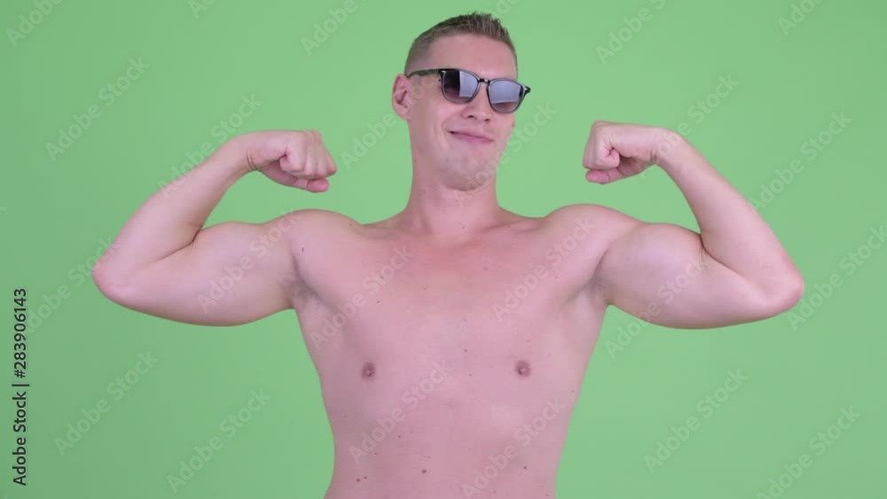 Happy shirtless young man flexing both arms Stock Video | Adobe Stock