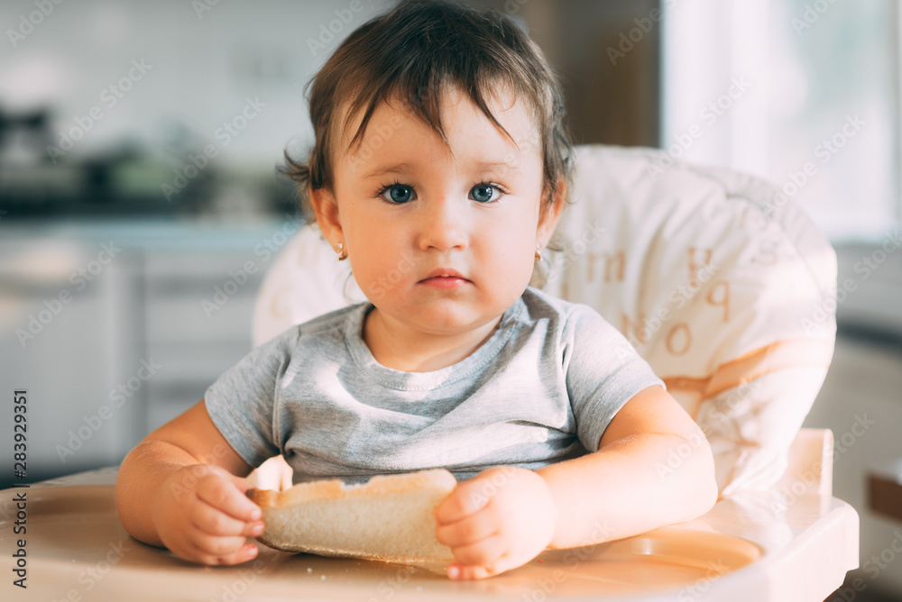 Baby girl is very greedy eating a piece of white bread, hungry Stock ...