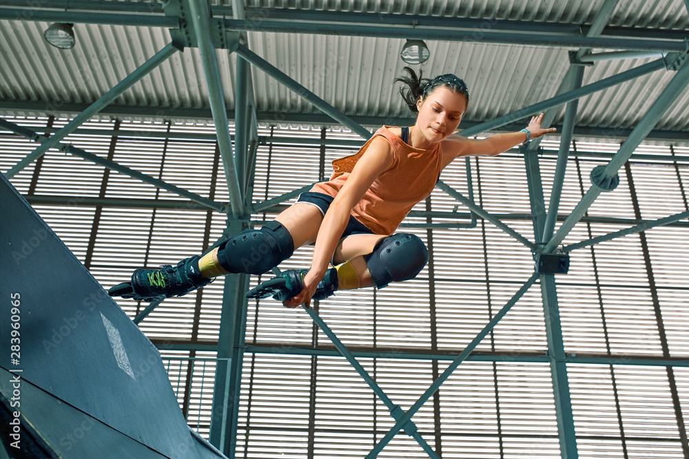 Rollerblader jump high from big air ramp performing trick. Indoors ...