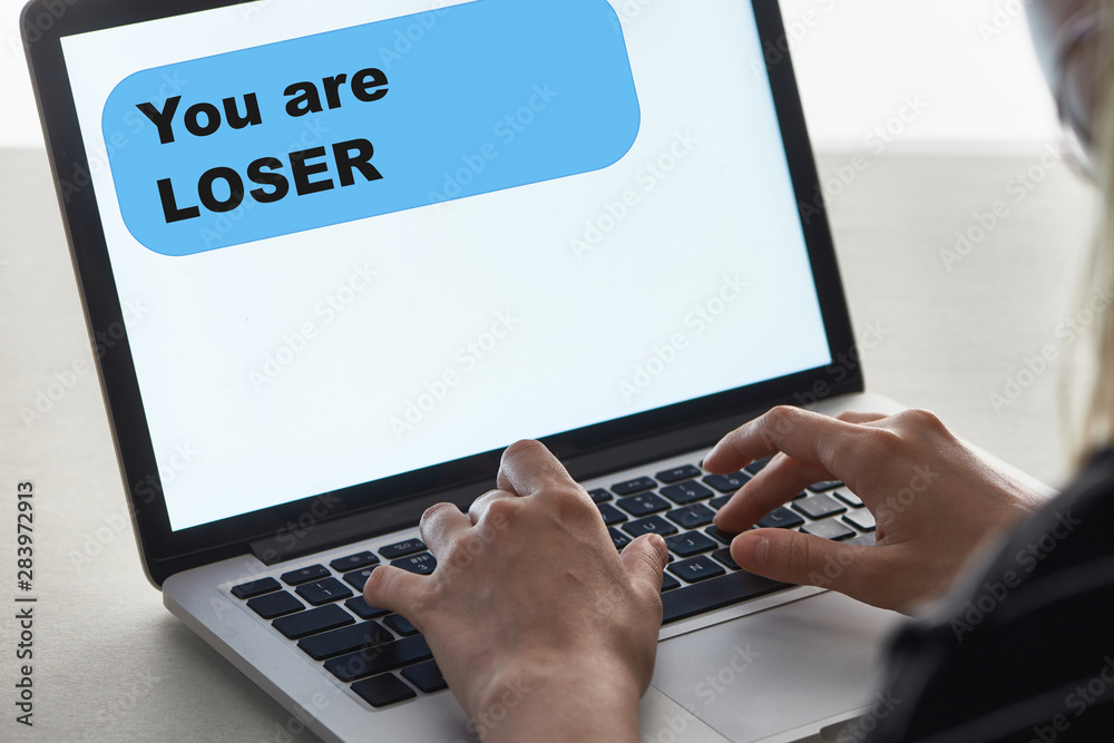 cropped view of girl typing on laptop keyboard with you are loser ...
