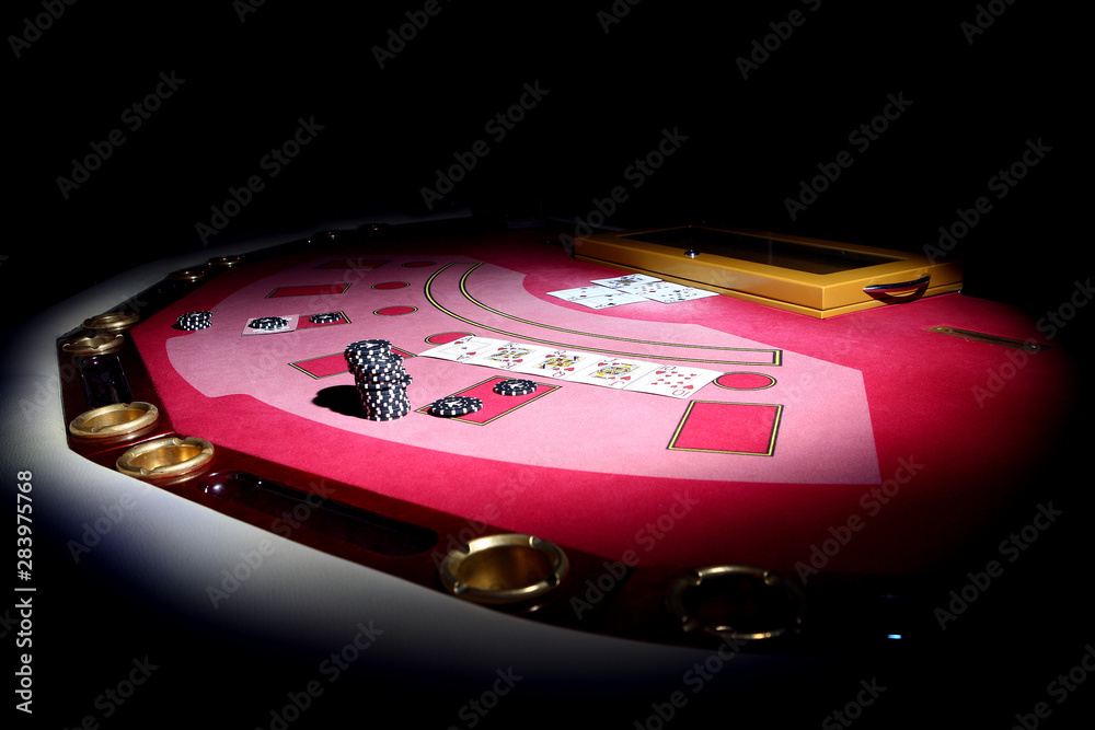 Red poker table on a black background with cards and tokens without ...