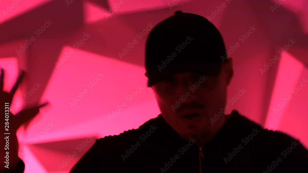 Rapper man dancing to the music. Silhouette on a dark red background ...