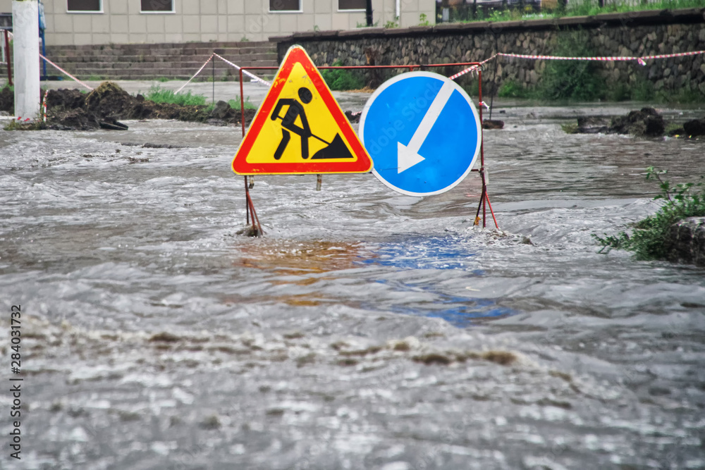 Flood on a city street after heavy rain. Flooded traffic signs. The ...