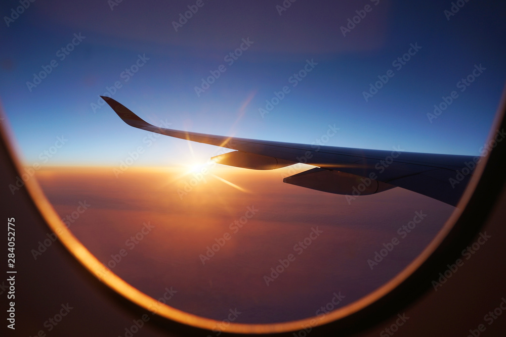 sunlight through airplane window from wing during sunrise Stock Photo ...