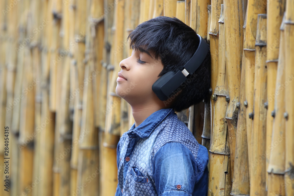 Indian young boy listen music with headphone Stock Photo | Adobe Stock