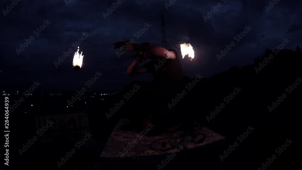 Cool male fire show stuntman performing, flailing around with his ...