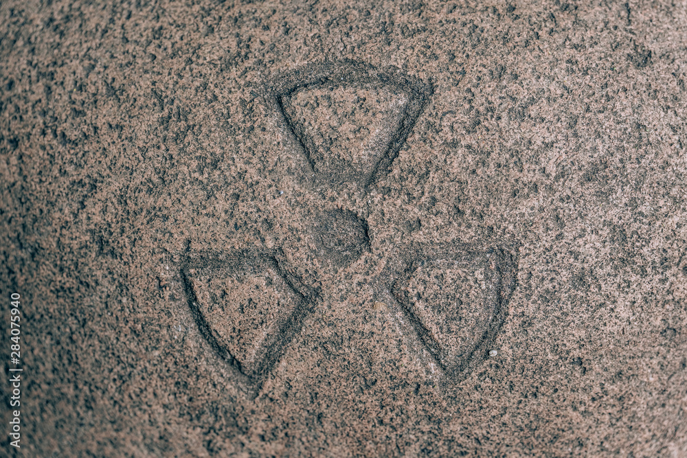 Nuclear sign carved on the stone. Symbol of danger on granite. Stone ...