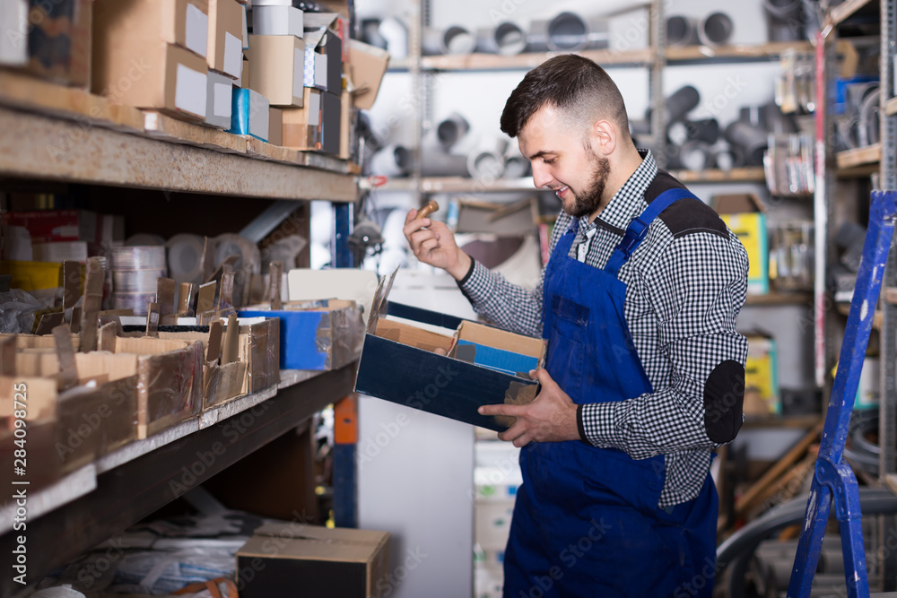Young smiling guy worker sorting sanitary engineering details Stock ...